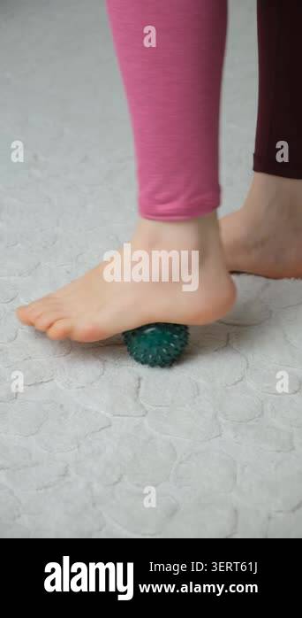 Woman Rolling Spiky Massage Ball Under Foot for Plantar Fascia Relief ...
