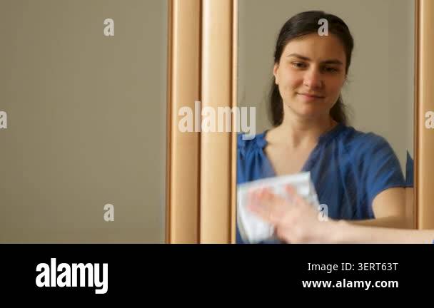 Housewife doing housework and polishing mirror reflection slow motion ...