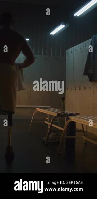Young Athlete with Prosthetic Leg Walks Through Bright, Sunlit Locker ...