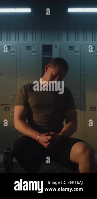 Young Man with Prosthetic Leg Sits on Bench in Dimly Lit Locker Room ...