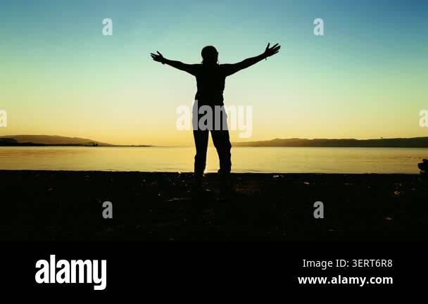 Young Woman Silhouette is Turning Around With Open Arms to the Sky in ...