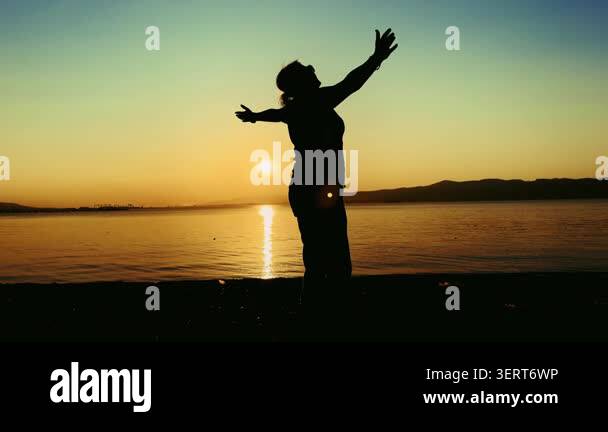 Young Woman Silhouette is Turning Around With Open Arms to the Sky in ...