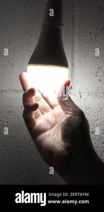 Male hand screwing in modern led Light bulb on light socket fixture at ...