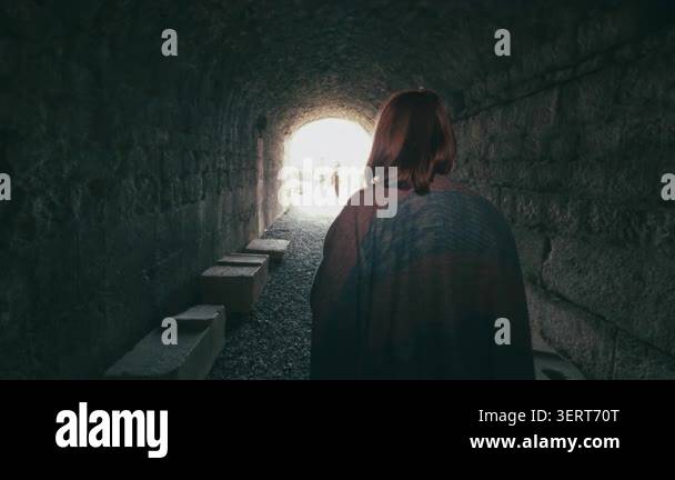 Young Woman Walks Through a Tunnel with Light at the End View Stock ...