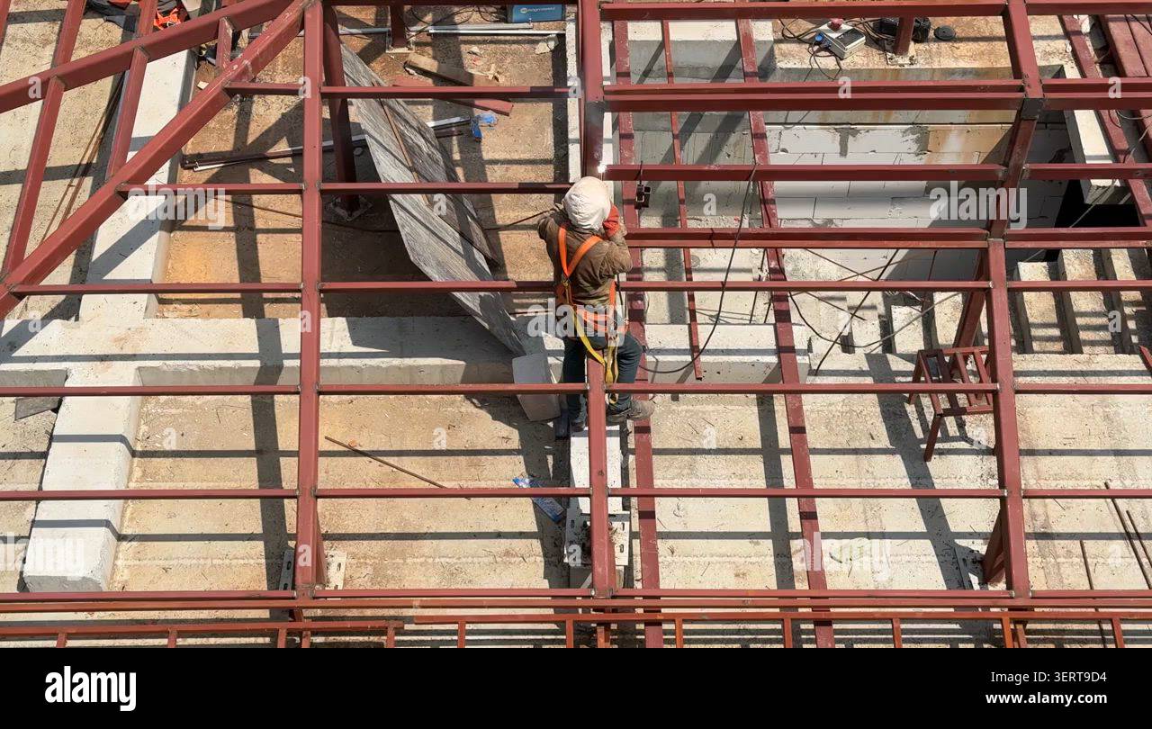 Construction Worker Welding On Steel Roof Framing With Safety Harness ...