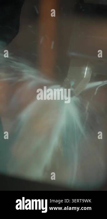 An industrial cutting tool sprays coolant while machining metal ...