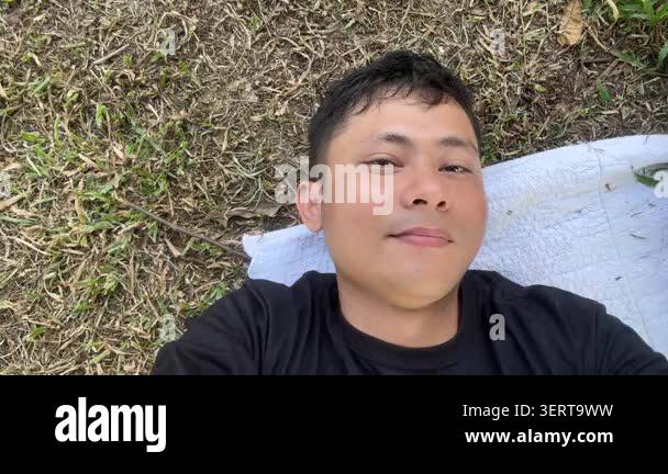 Asian Man Lying on Grass Making Playful Facial Expressions Stock Video ...