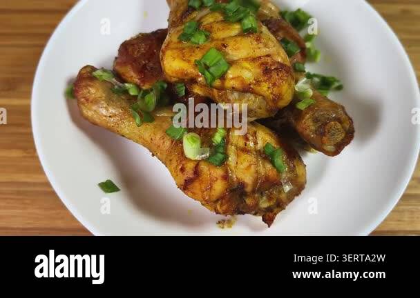 Grilled chicken drumsticks on a plate on a wooden surface Stock Video ...