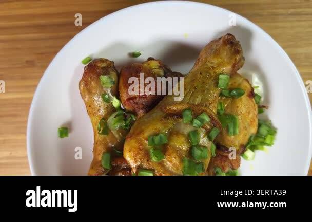 Grilled chicken drumsticks on a plate on a wooden surface Stock Video ...