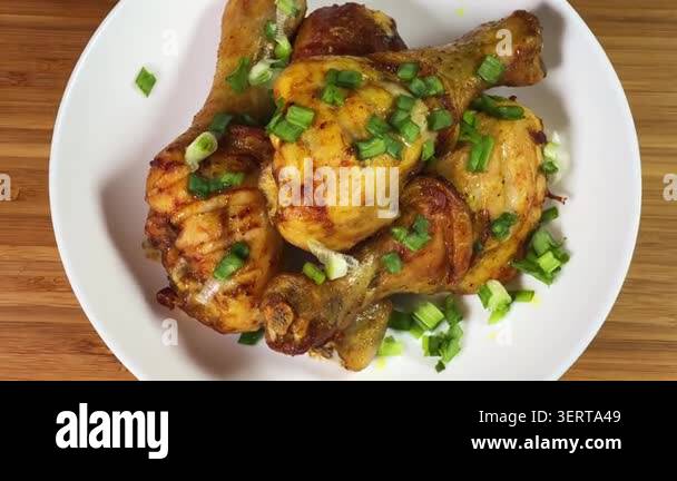 Grilled chicken drumsticks on a plate on a wooden surface Stock Video ...