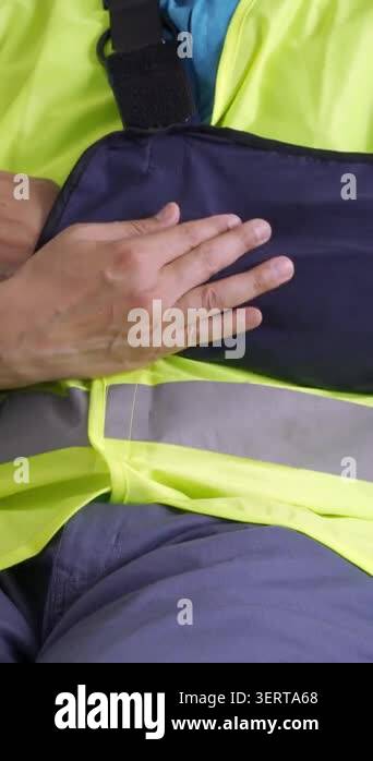 Close up of a repairman grabbing his painful bandaged arm on a couch at ...