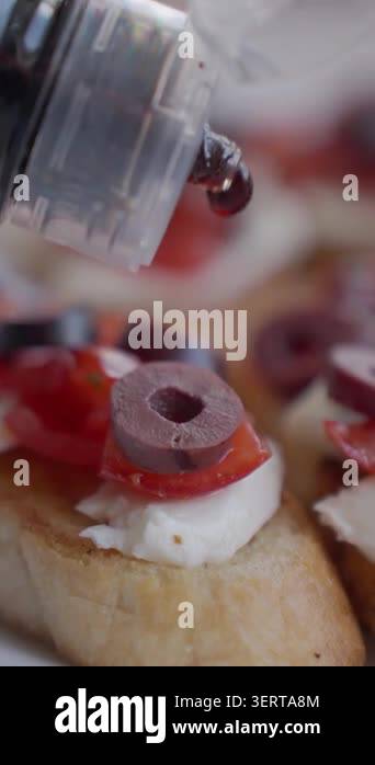 Balsamic sauce is added to bruschetta with mozzarella, tomato and black ...