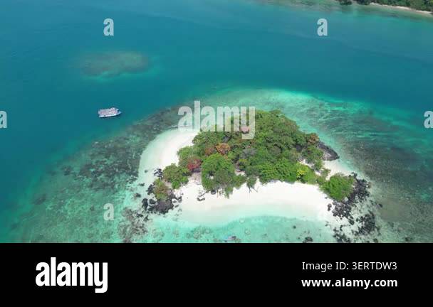 Aerial orbit of an idyllic small tropical island with a white sand ...