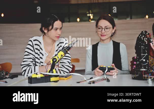 Helpful female teacher use remote controller to operate yellow robotic ...