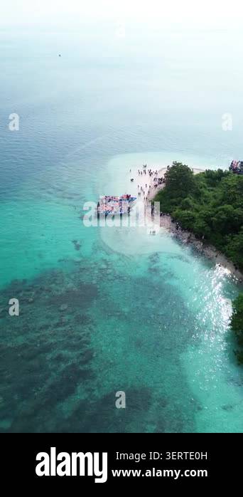 Vertical aerial of a small island point with a tour boat of visitors ...