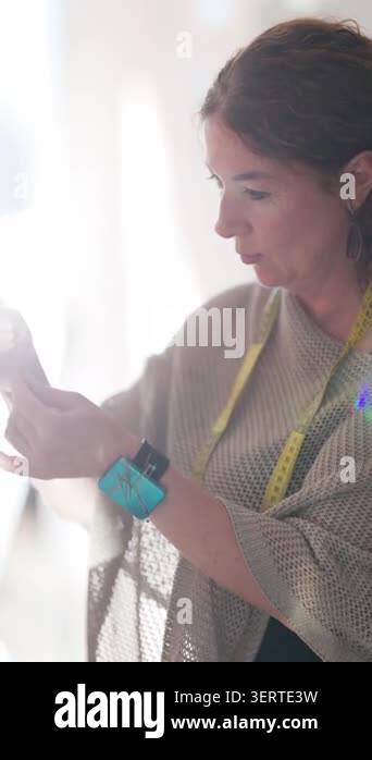 Focused seamstress with a measuring tape carefully sews a piece of ...