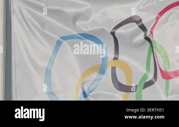 White olympic flag with its five interlocking rings waving majestically ...