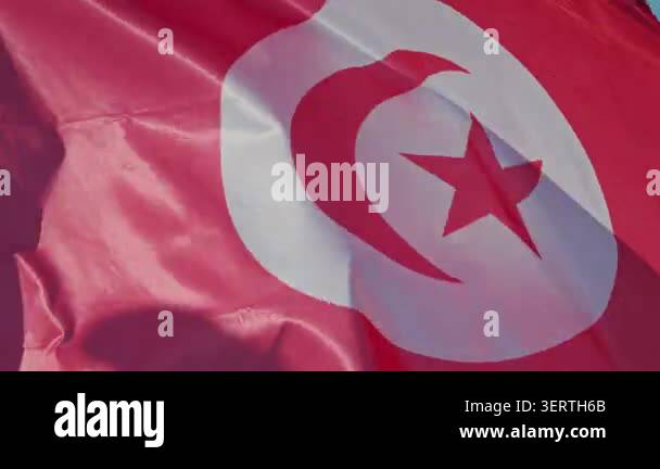 Red and white tunisian national flag with its star and crescent emblem ...