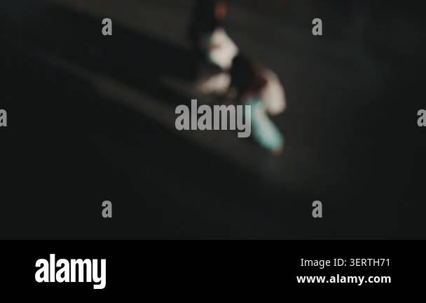 Footsteps echo as individuals move along a dark street in a city. The ...