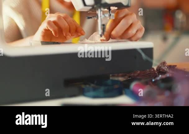 Close-up of a tailor working on an electric sewing machine in a ...