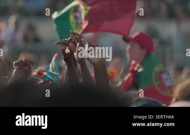 Crowd of soccer supporters waving portuguese flags and cheering for ...