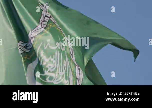 Arab league green flag with its emblem waving in slow motion against a ...