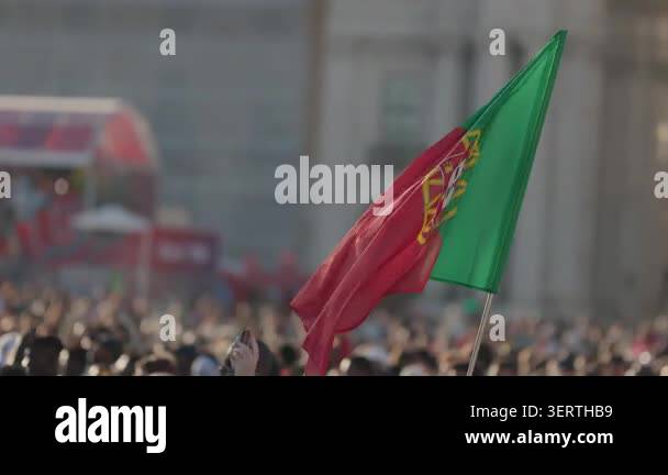 Supporter holding a portugal flag waving in the wind during a soccer ...