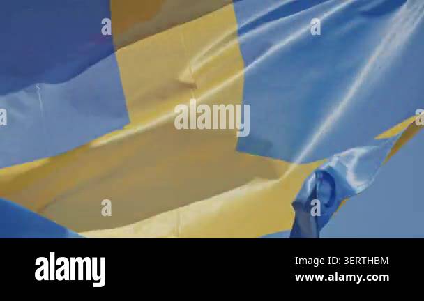 Swedish national flag with its blue and yellow cross emblem waving in ...