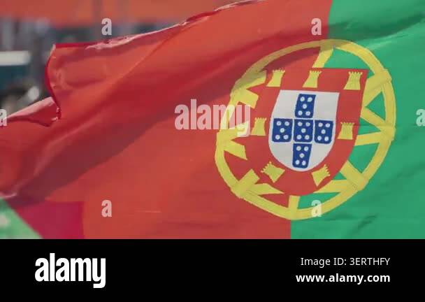 Portuguese flag waving in slow motion in a stadium full of football ...