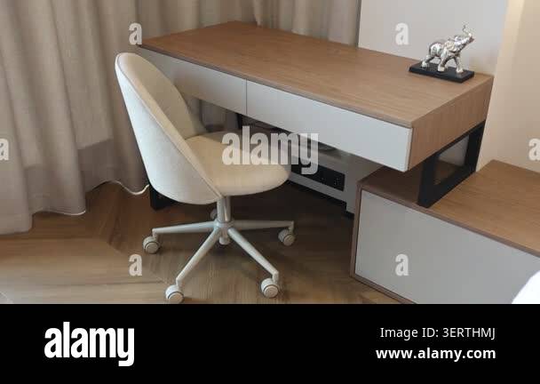 A tidy indoor workspace with a wooden desk against the back wall, a ...