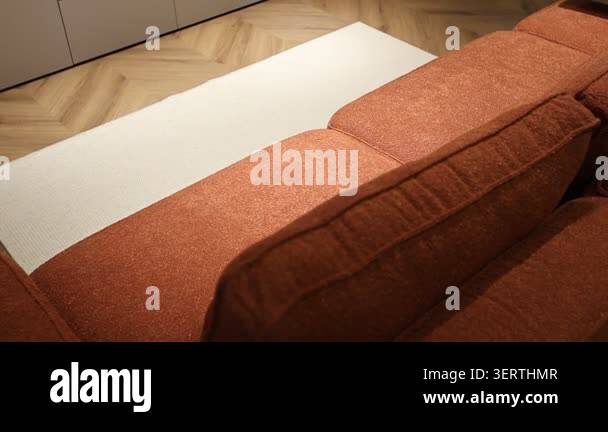 Warm indoor scene featuring an orange upholstered sofa in the right ...
