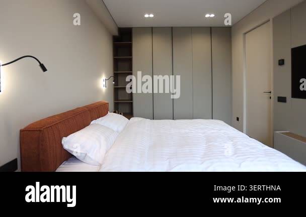 Calm residential bedroom interior with soft ceiling lighting, beige ...