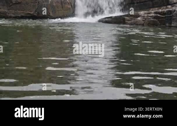 A beautiful fast flowing waterfall. Water cascades down from a steep ...