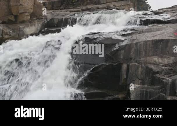 A beautiful fast flowing waterfall. Water cascades down from a steep ...