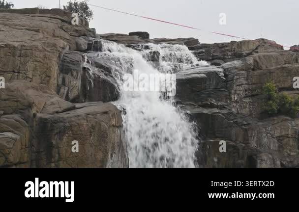 A beautiful fast flowing waterfall. Water cascades down from a steep ...