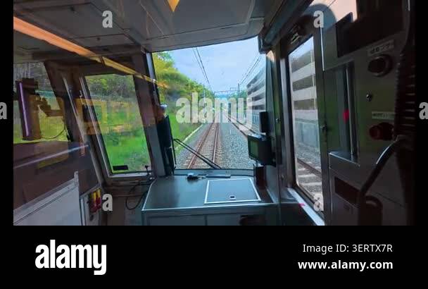 Japanese train driver perspective from cabin moving along urban railway ...