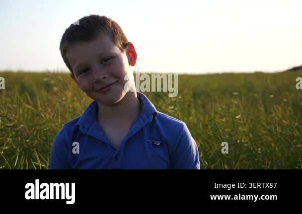 Happy child looks into camera and giving a thumb up against background ...