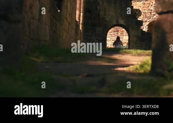 Woman jumping in Kirkstall Abbey Church ruins arch windows in Leeds ...