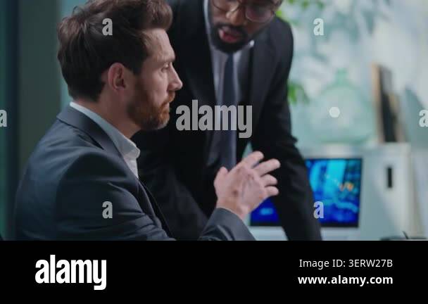 Two multiethnic business men discussing online computer job task with ...