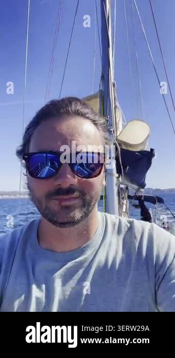 Bearded man wearing sunglasses aboard sailing yacht Stock Video Footage ...