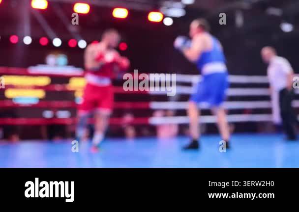 Blurred motion of two male boxers exchanging punches in the ring as a ...