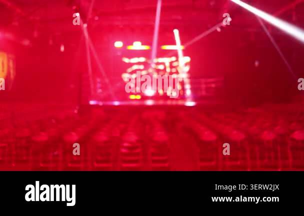 Empty boxing ring and rows of chairs bathed in dramatic red light with ...