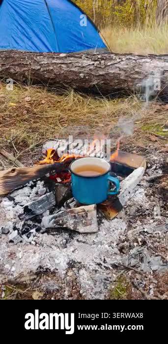 Cozy autumn camping scene with blue tents and a warm campfire with ...