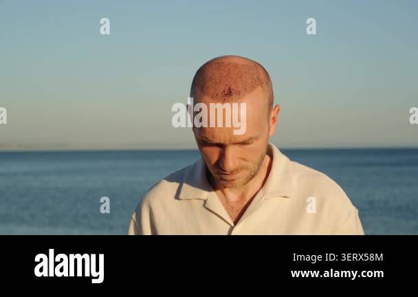 A portrait of a calm and slightly serious Caucasian man displaying ...