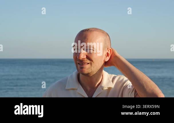 Portrait of a hesitant middle-aged man after a hair transplant ...