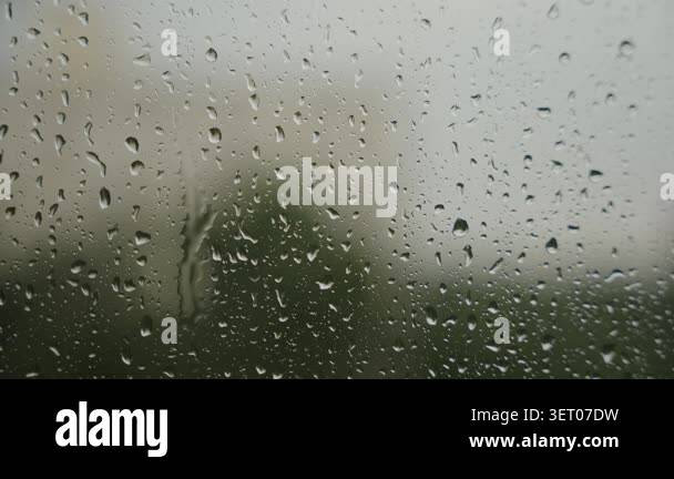 Large raindrops on the window during the rain against the background of ...