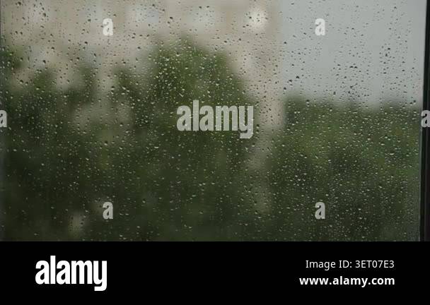 Large raindrops on the window during the rain against the background of ...