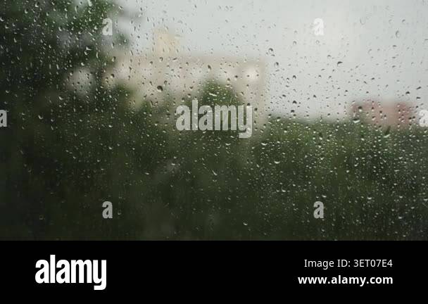 Large raindrops on the window during the rain against the background of ...