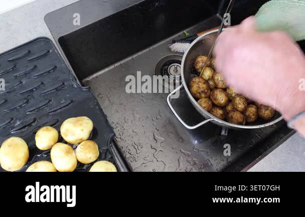 Stockholm, Sweden A man in a residential kitchen uses coarse gloves ...