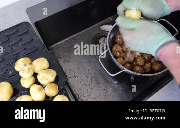Stockholm, Sweden A man in a residential kitchen uses coarse gloves ...